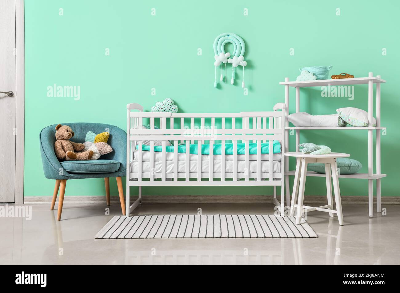 Interior of children's room with crib and armchair near turquoise wall ...