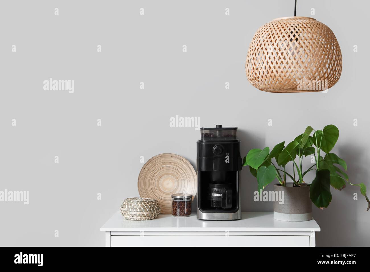 Modern coffee machine and plant on shelf near light wall Stock Photo ...