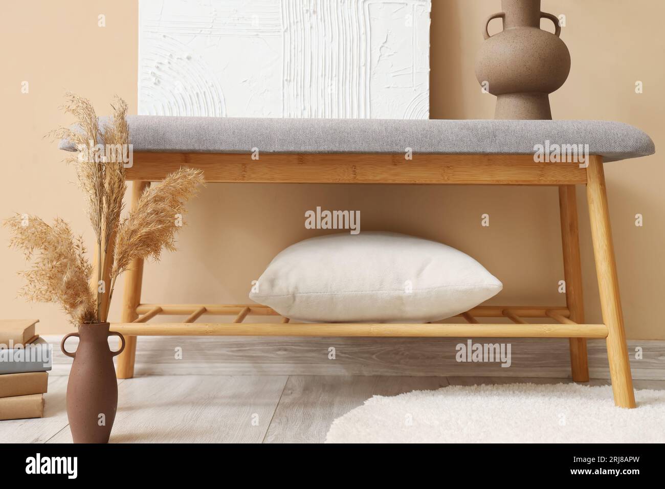 Interior of stylish room with soft bench near beige wall Stock Photo - Alamy