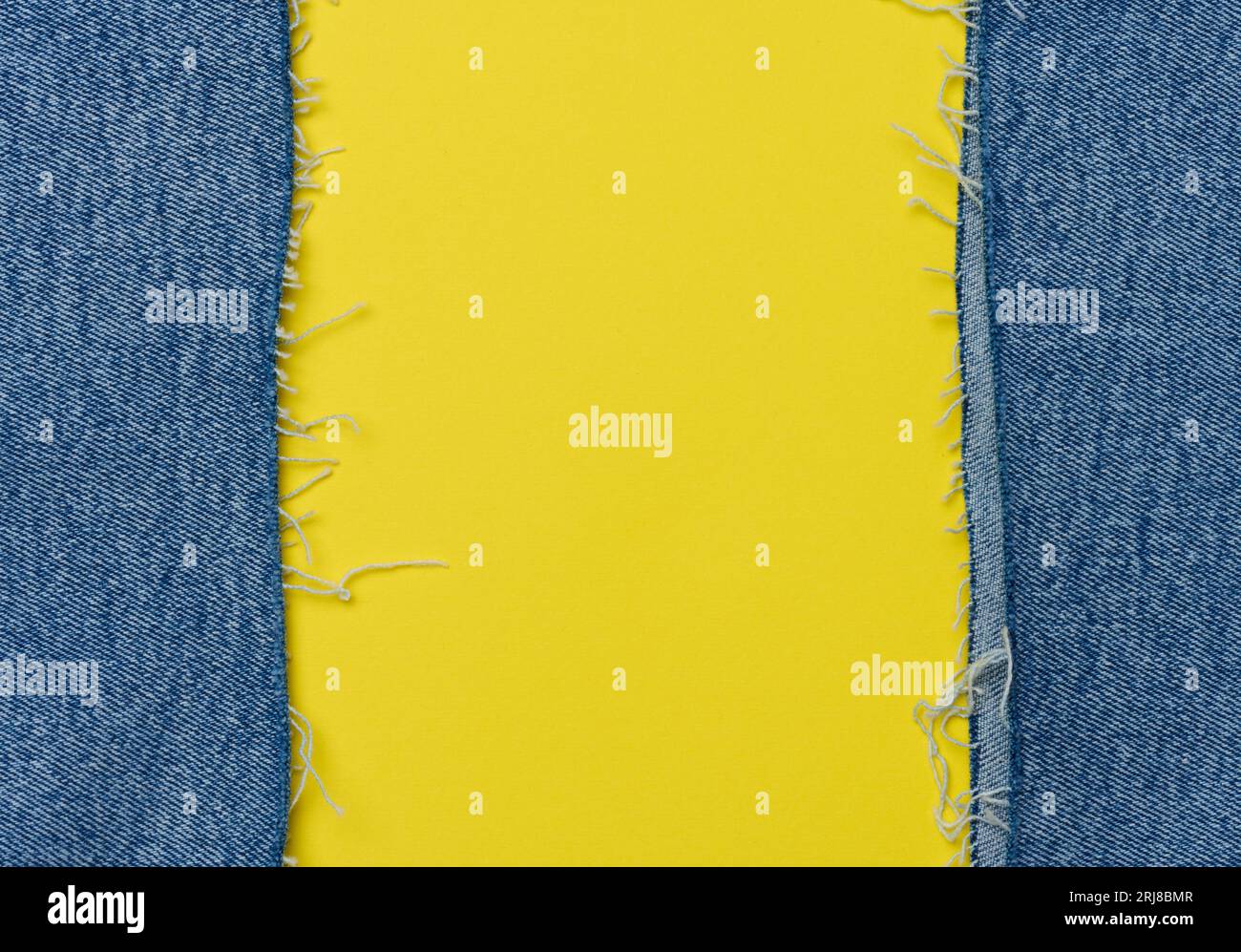 Torn edges of blue jeans on a yellow background Stock Photo - Alamy