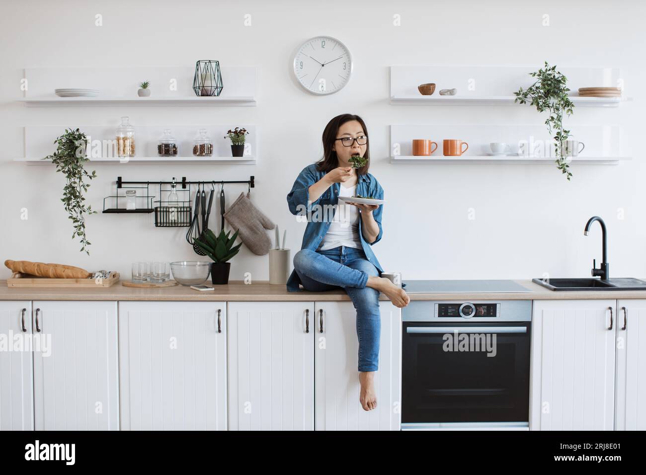 Female adult resting at home with vegetarian salad for lunch Stock ...