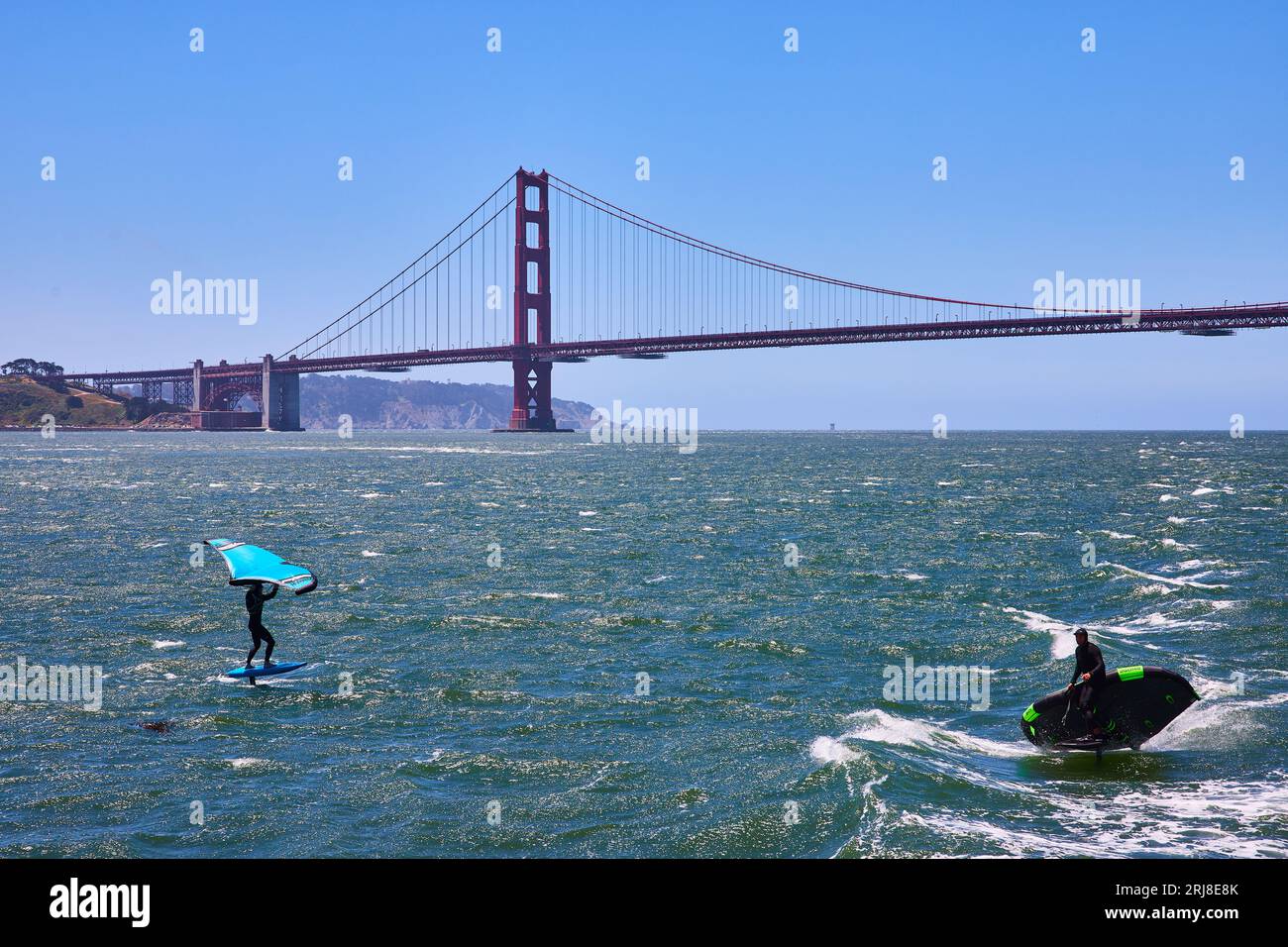 Two men sailboarding on choppy bay waters with Golden Gate Bridge ...