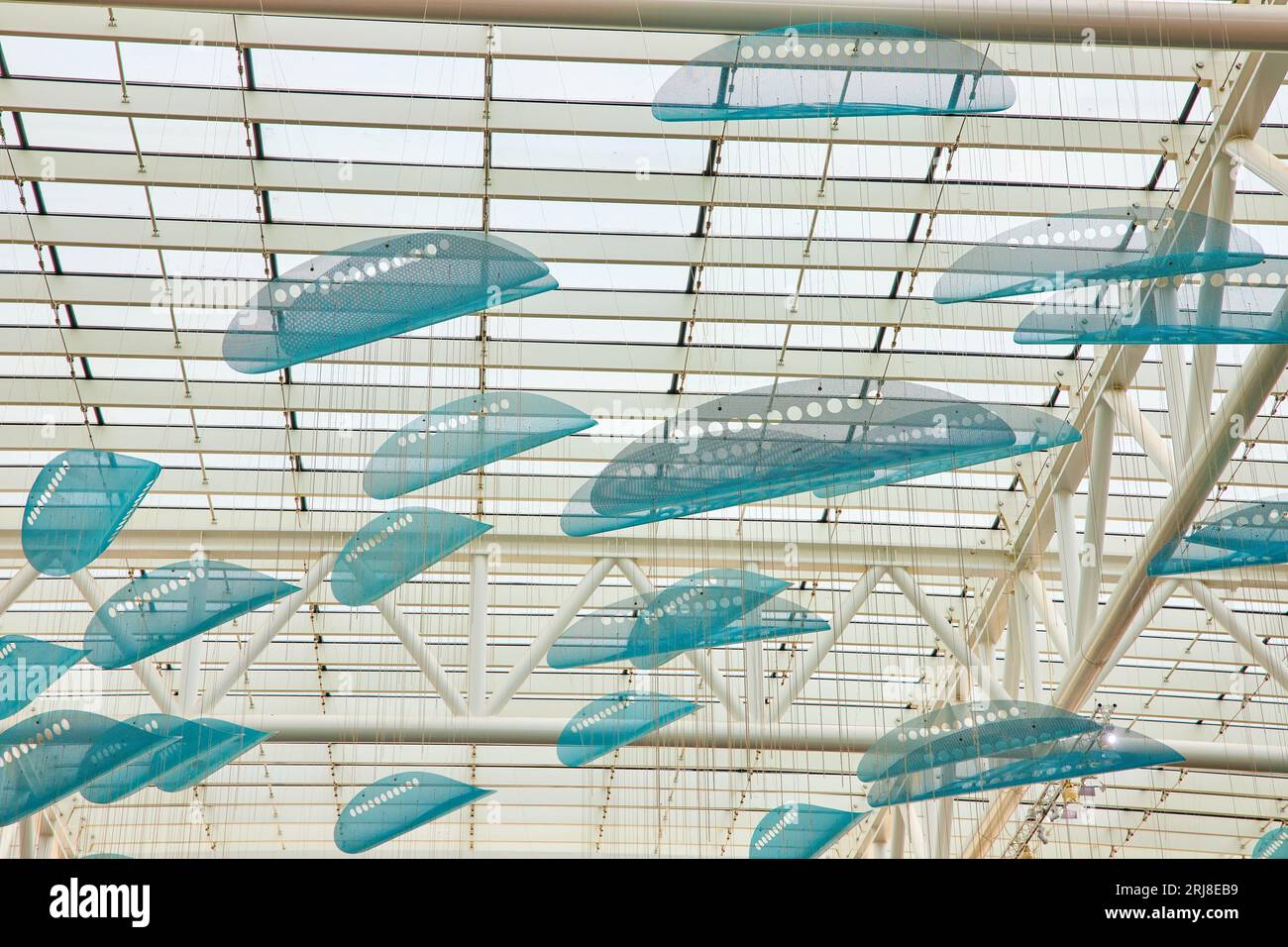 White ceiling with windows to white sky and hanging blue abstract art ...