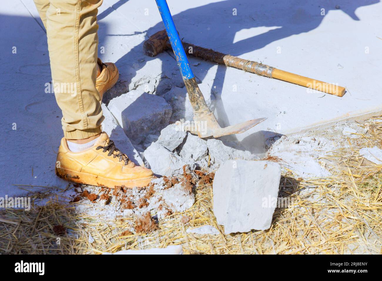 Demolition worker breaks concrete old driveway using hammer on ...