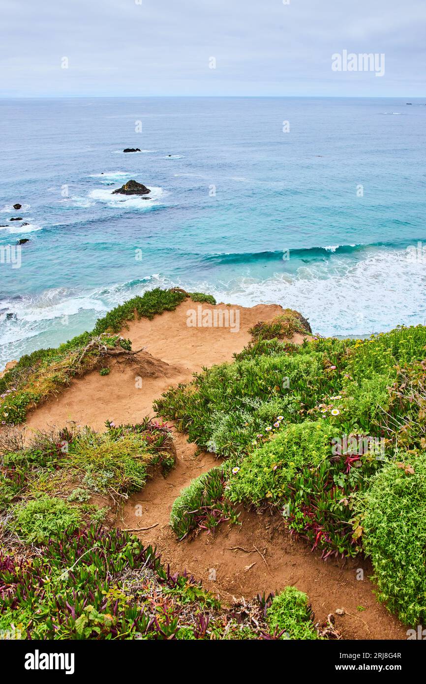 Sandy green trail overlooking scenic teal and navy blue ocean waves ...
