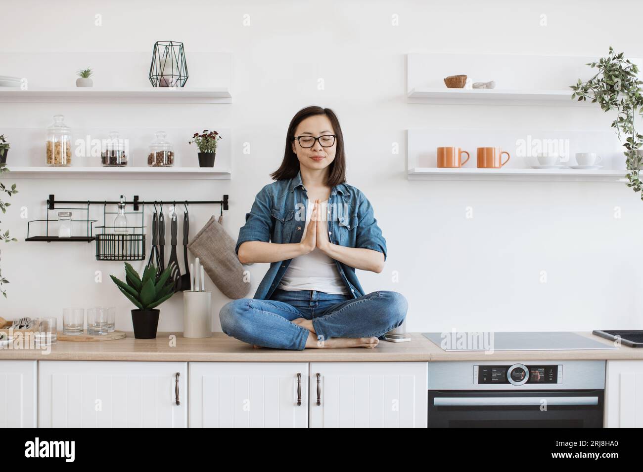 Lady greeting day with namaste in lotus pose on worktop Stock Photo - Alamy