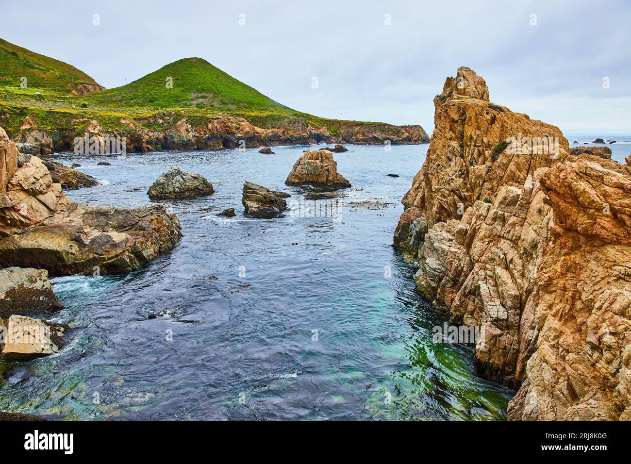 Watery inlet between rocky cliff walls with view of distant green ...