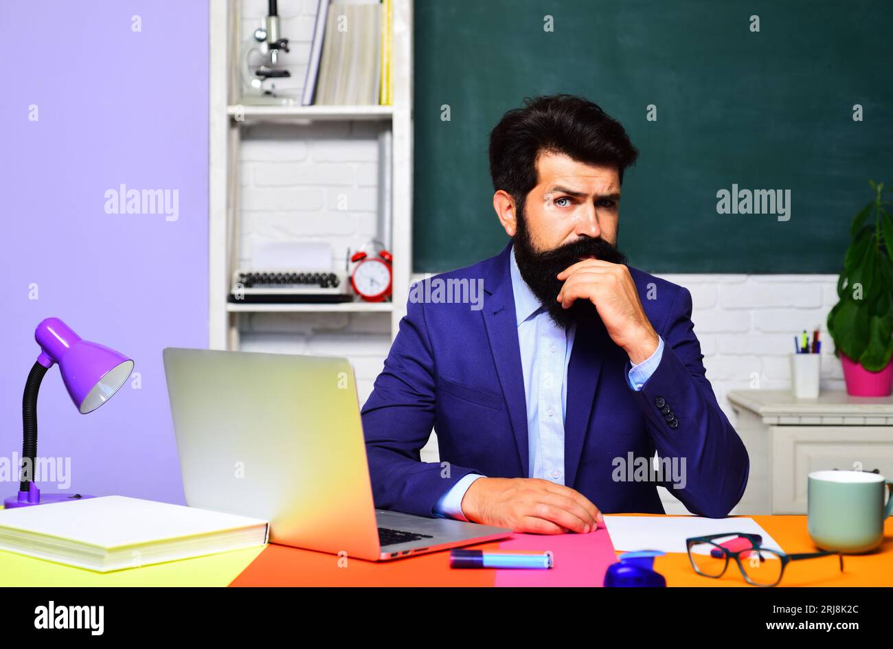 Serious male teacher at workplace. Profession and learning. High school ...