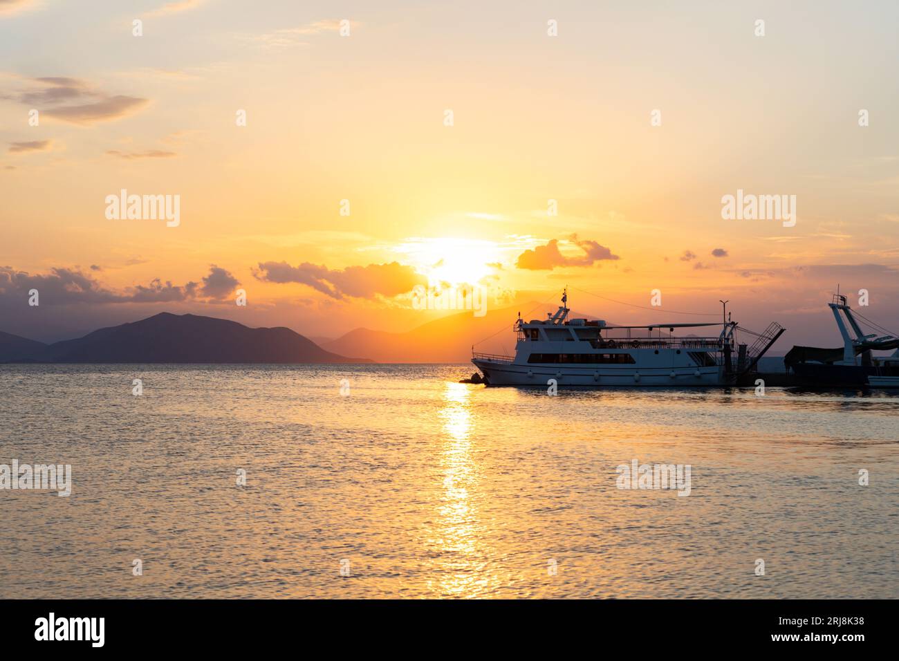 Ships and boats in the harbour at sunset at the island of Evia in ...