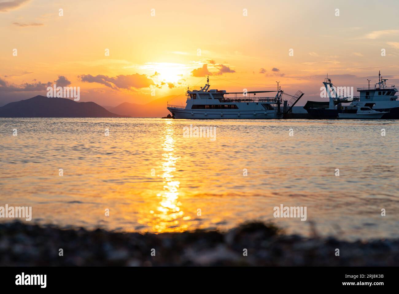 Ships and boats in the harbour at sunset at the island of Evia in ...