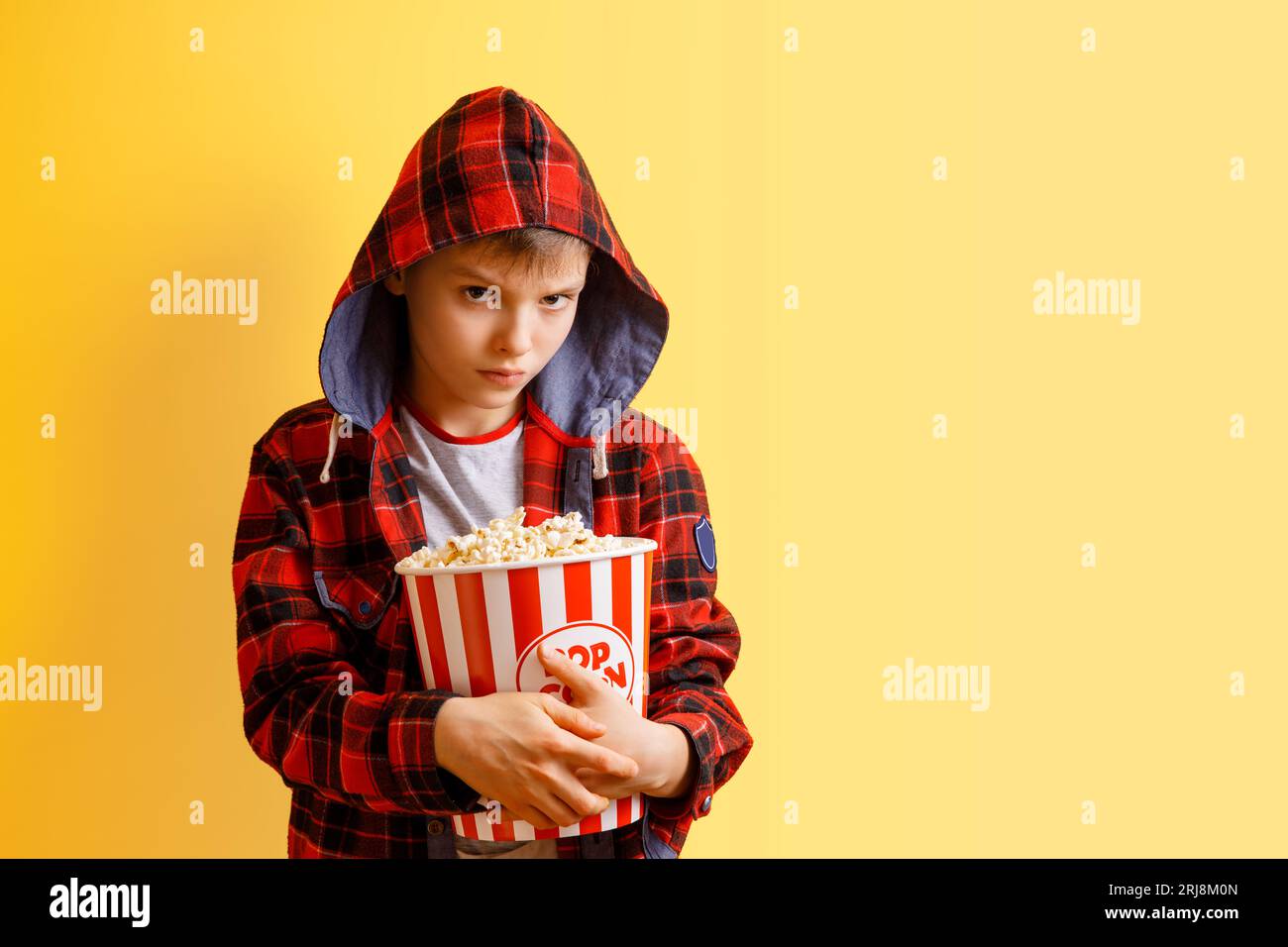 Boy offended and angry with huge popcorn bucket Stock Photo - Alamy