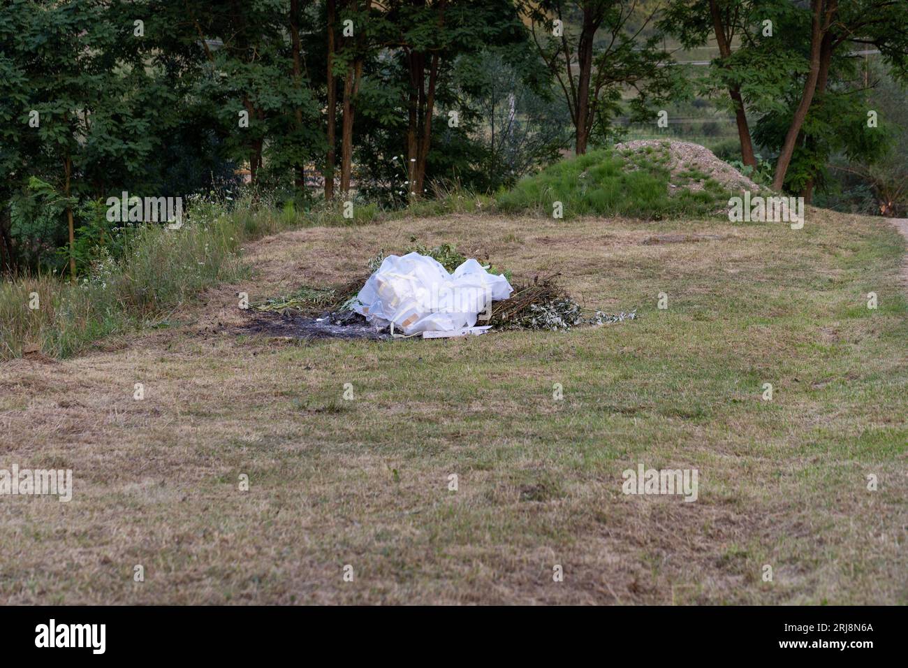 Plastic disposed of and burned in a field in rural set-up. Pollution ...