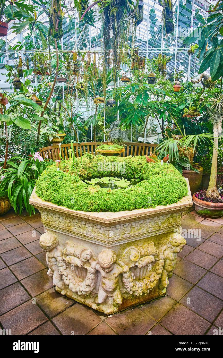 Large concrete planter with angels and harps around outside and pool of ...