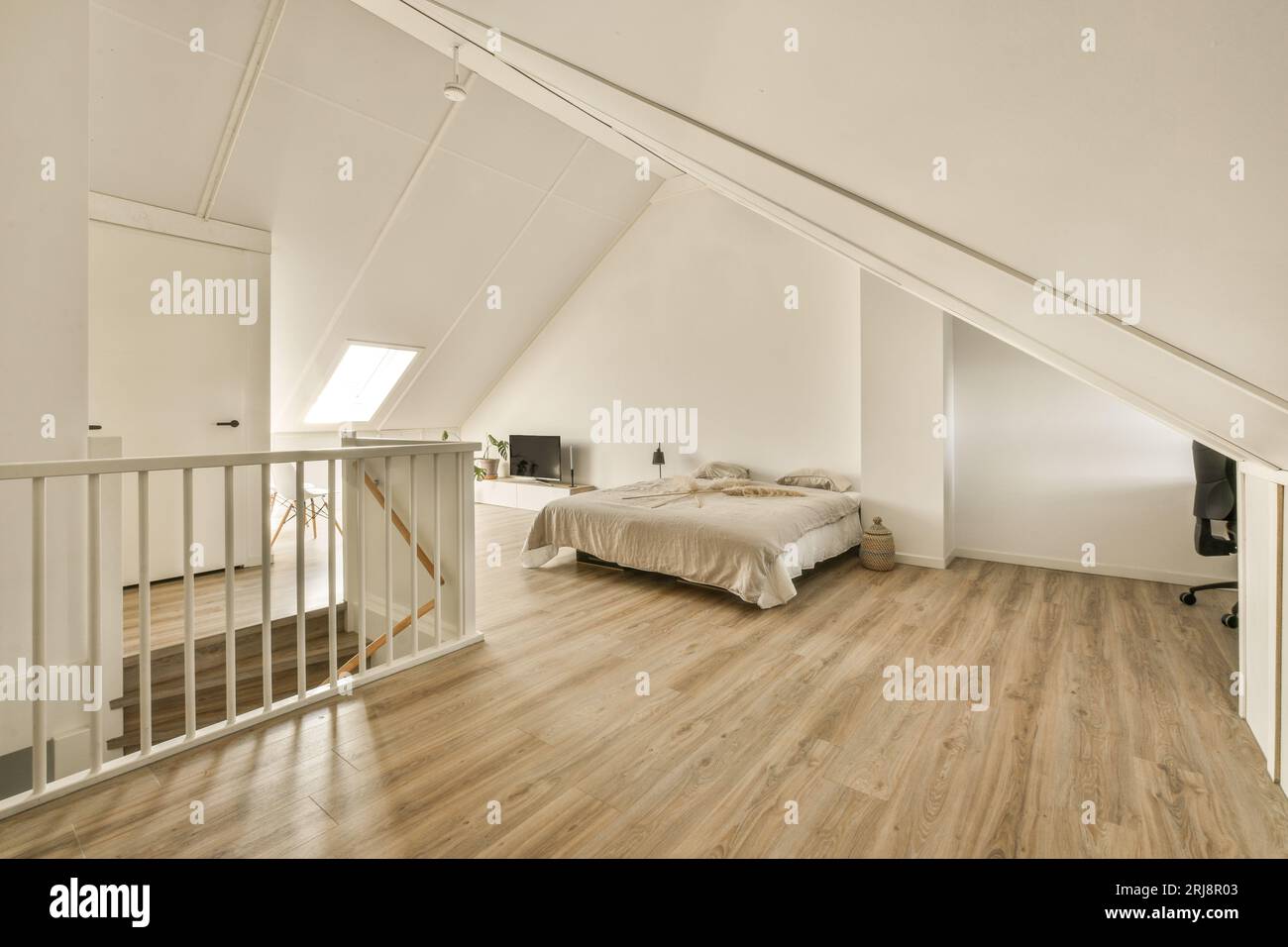 a bedroom with wood flooring and white walls in an attic - style home ...