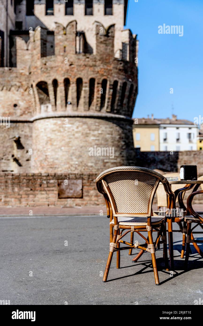 A cafè with outdoor tables in front of the Medieval castle "Rocca ...