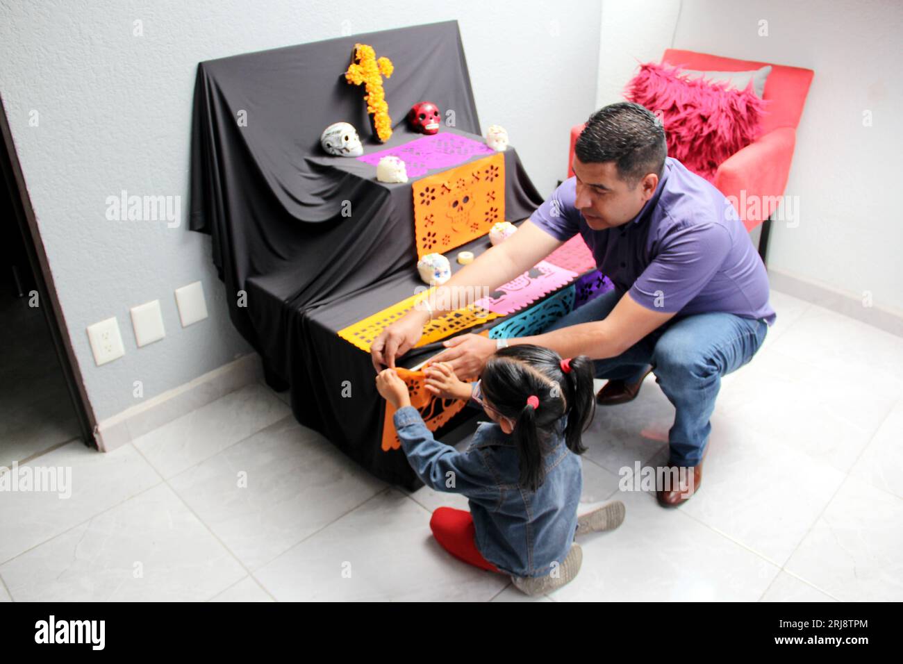 Mexican dad and daughter put the altar and offering of the Day of the ...