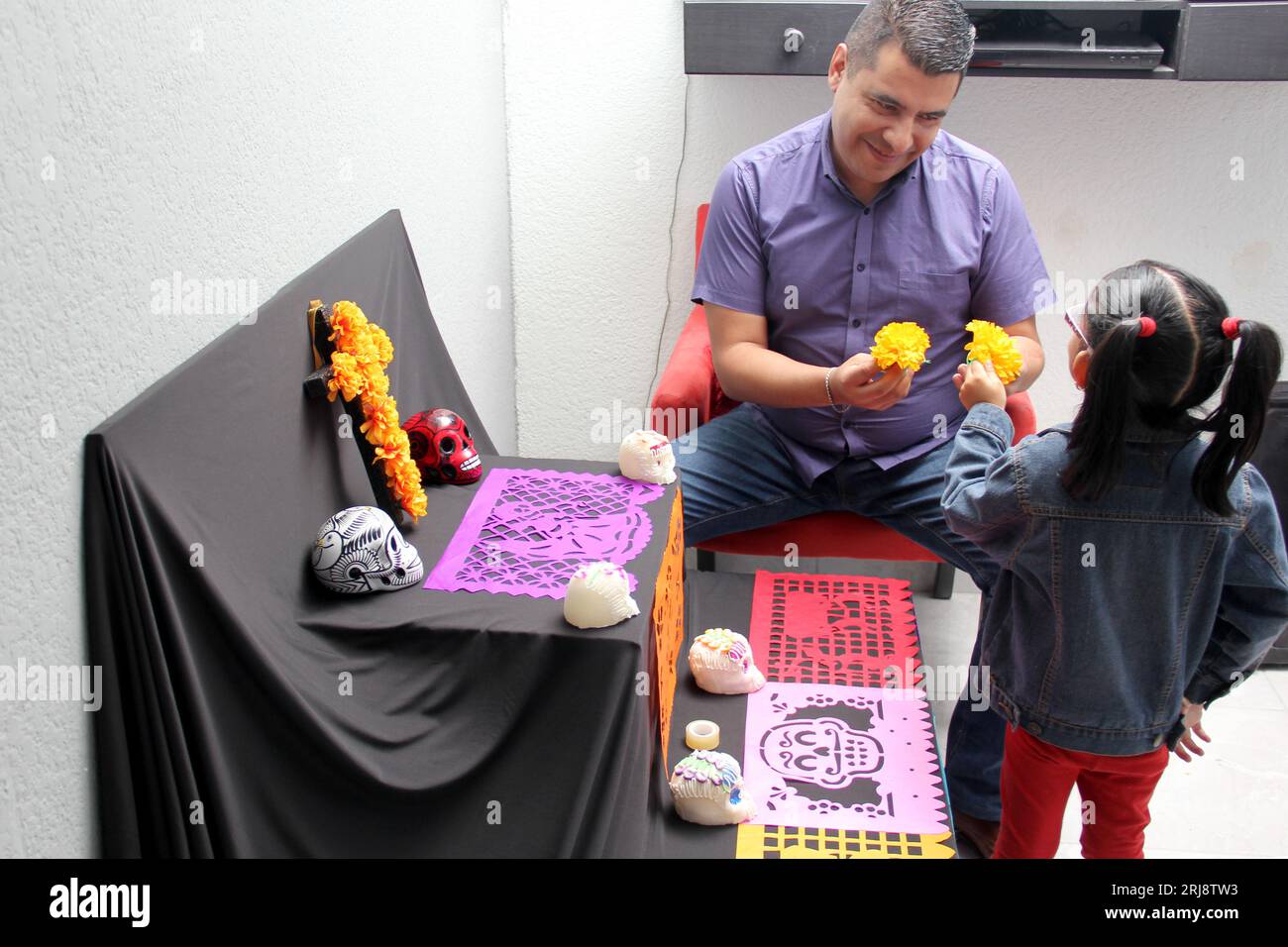 Mexican dad and daughter put the altar and offering of the Day of the ...