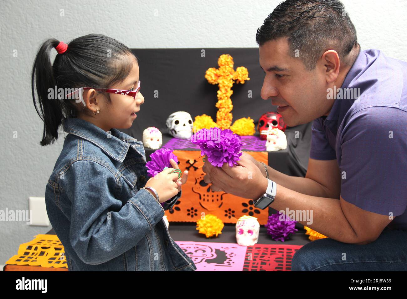 Mexican dad and daughter put the altar and offering of the Day of the ...