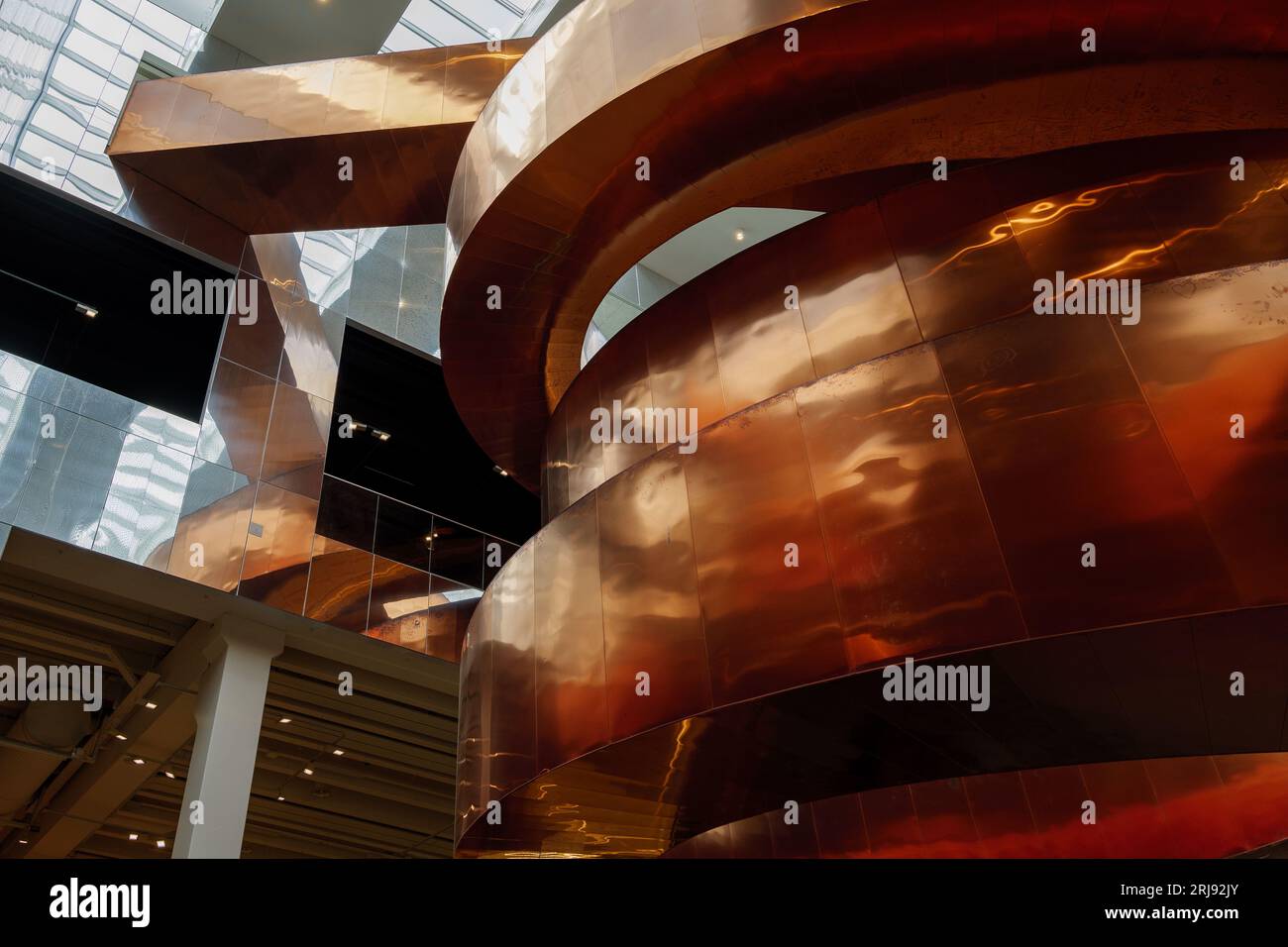 Interior view at the atrium with iconic curvature copper staircase at ...