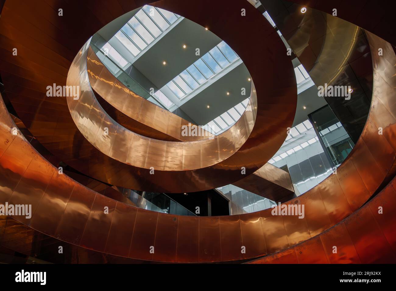 Interior view at the atrium with iconic curvature copper staircase at ...