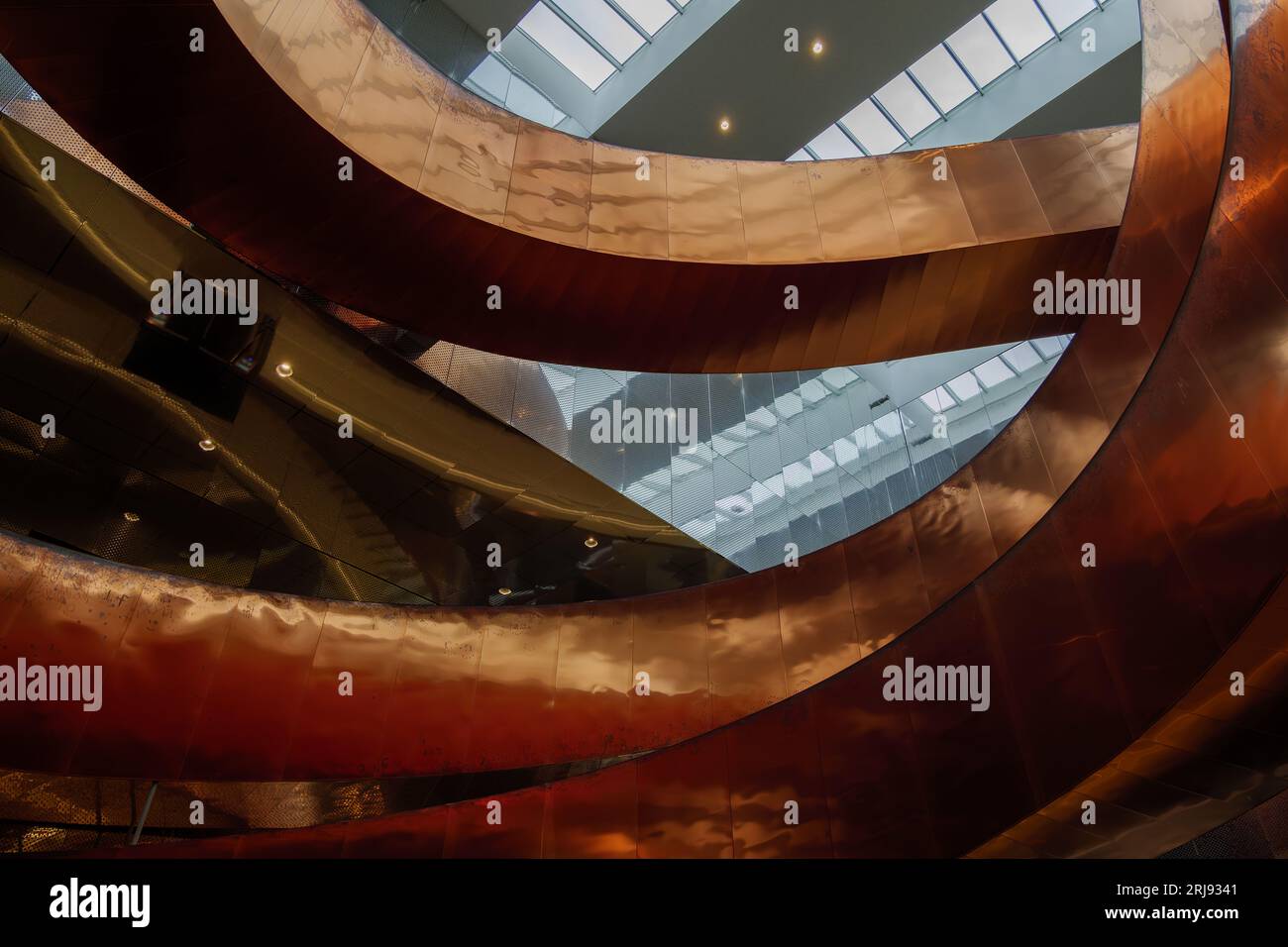 Interior view at the atrium with iconic curvature copper staircase at ...
