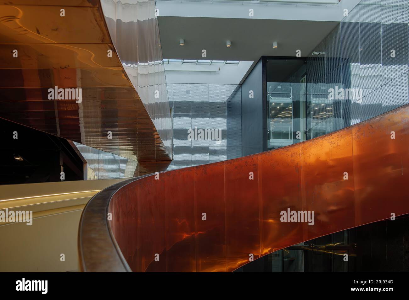 Interior view at the atrium with iconic curvature copper staircase at ...