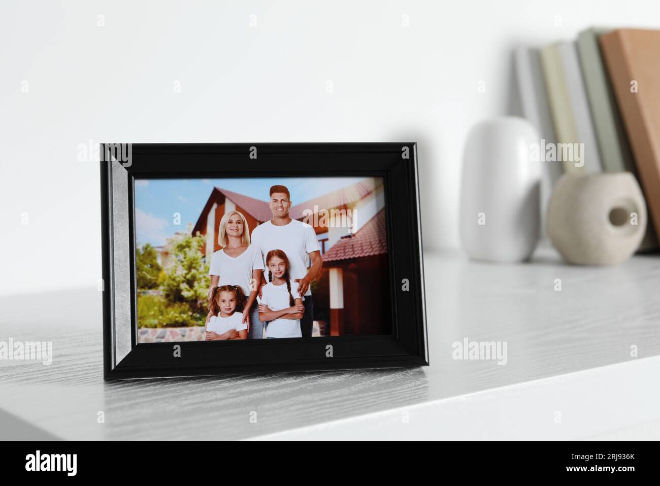 Frame with family photo on white chest of drawers indoors Stock Photo ...