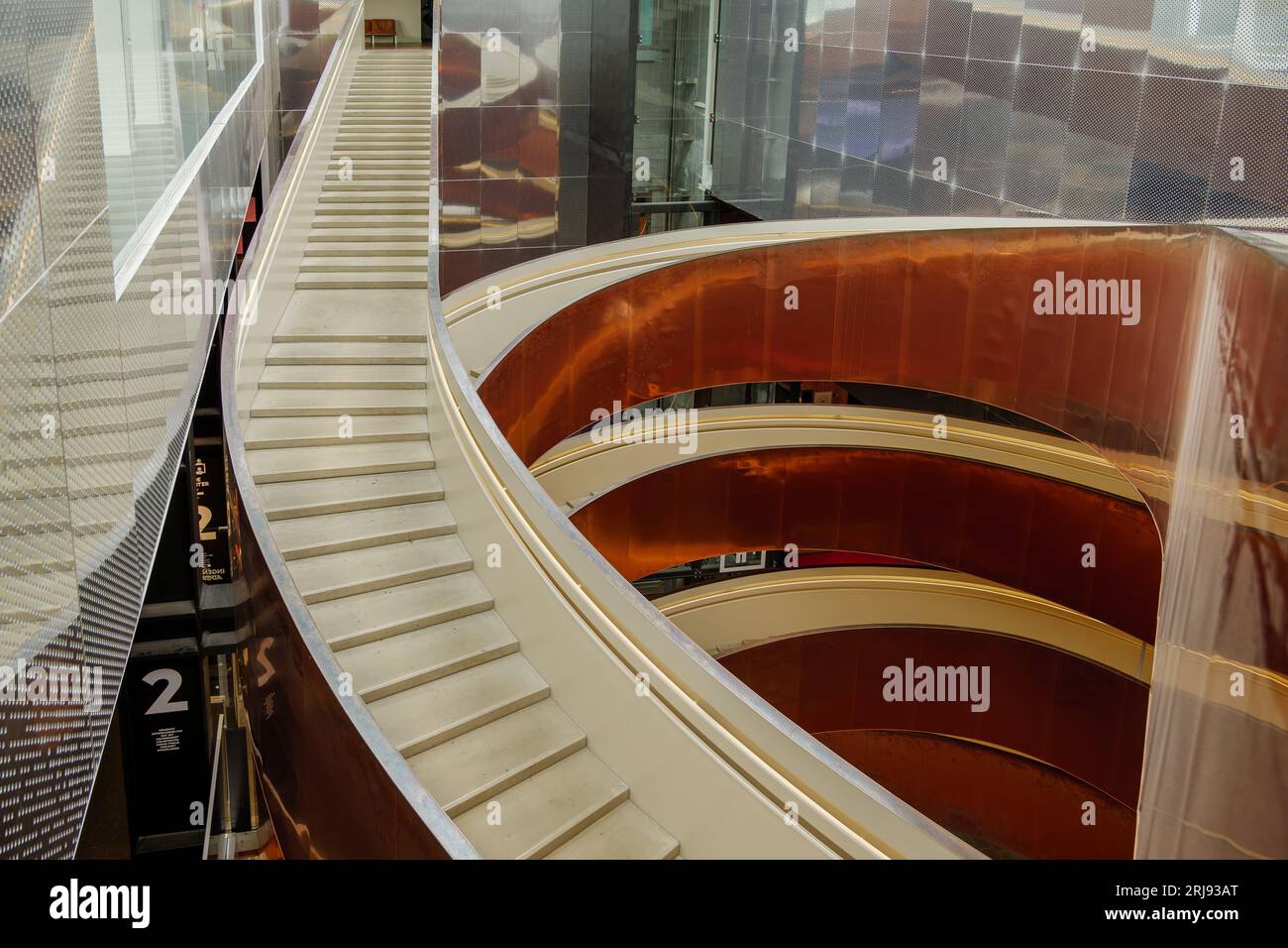 Interior view at the atrium with iconic curvature copper staircase at ...