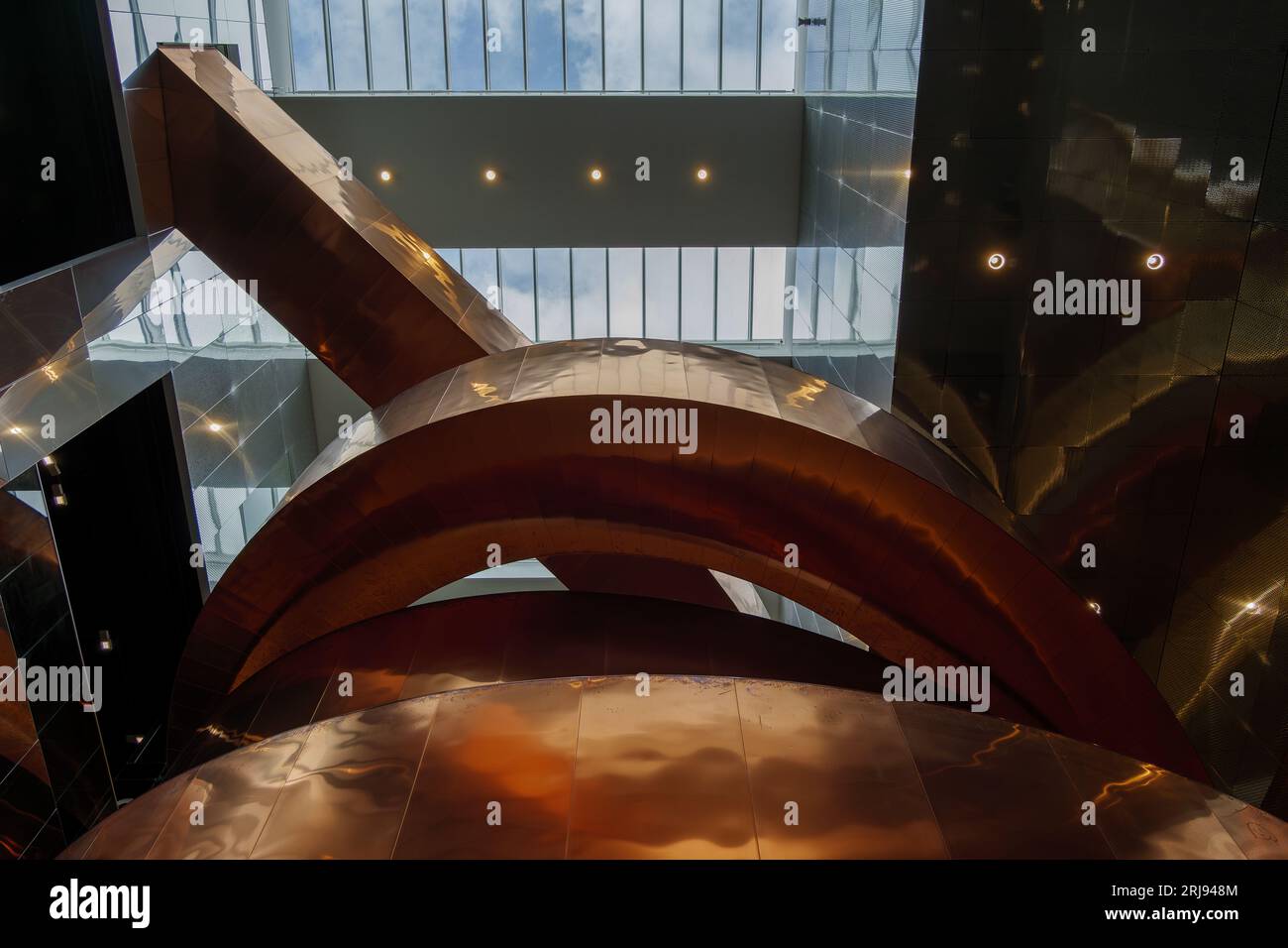 Interior view at the atrium with iconic curvature copper staircase at ...