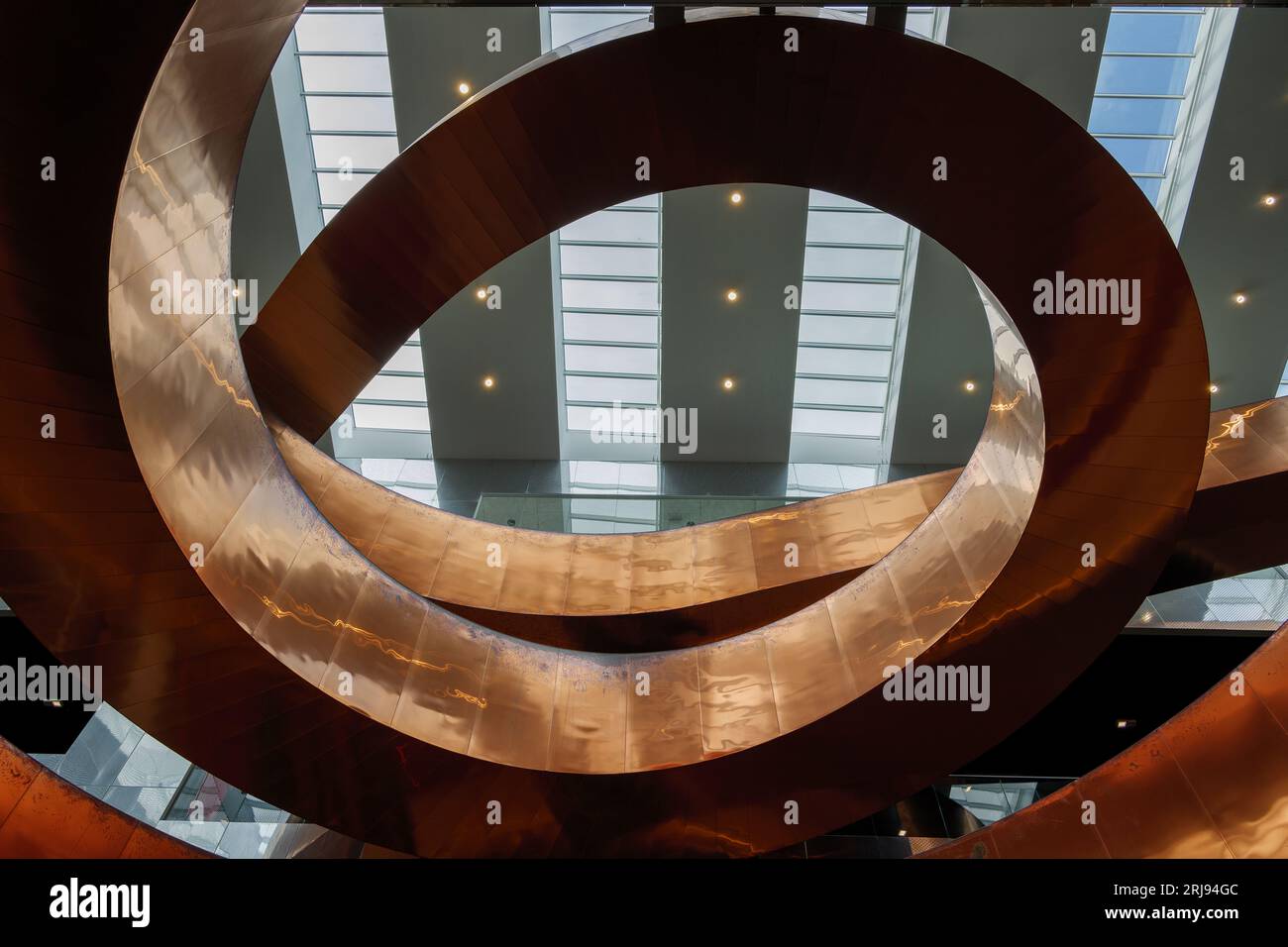 Interior view at the atrium with iconic curvature copper staircase at ...