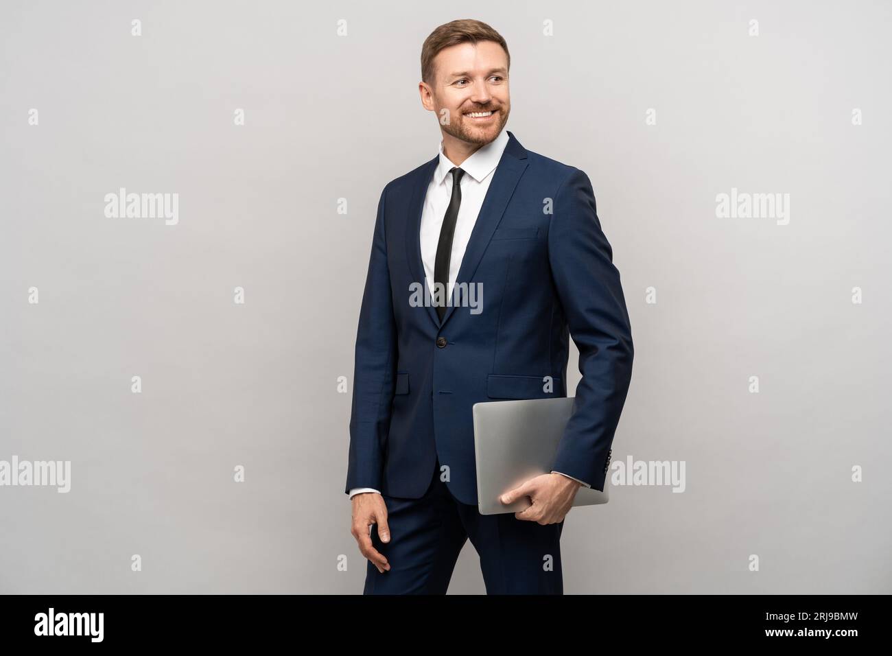 Successful male businessman confident look with laptop in hand standing ...