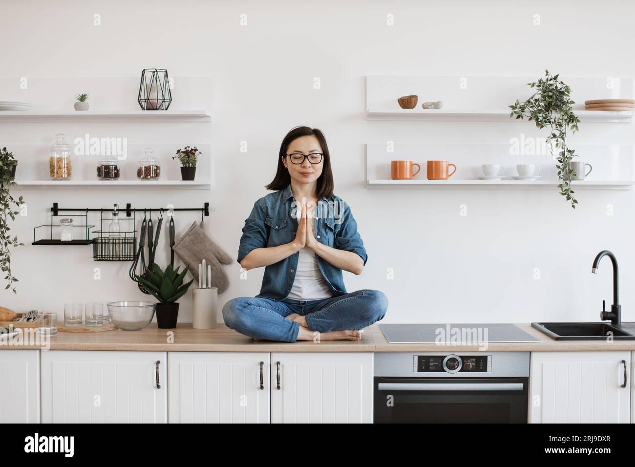 Lady greeting day with namaste in lotus pose on worktop Stock Photo - Alamy