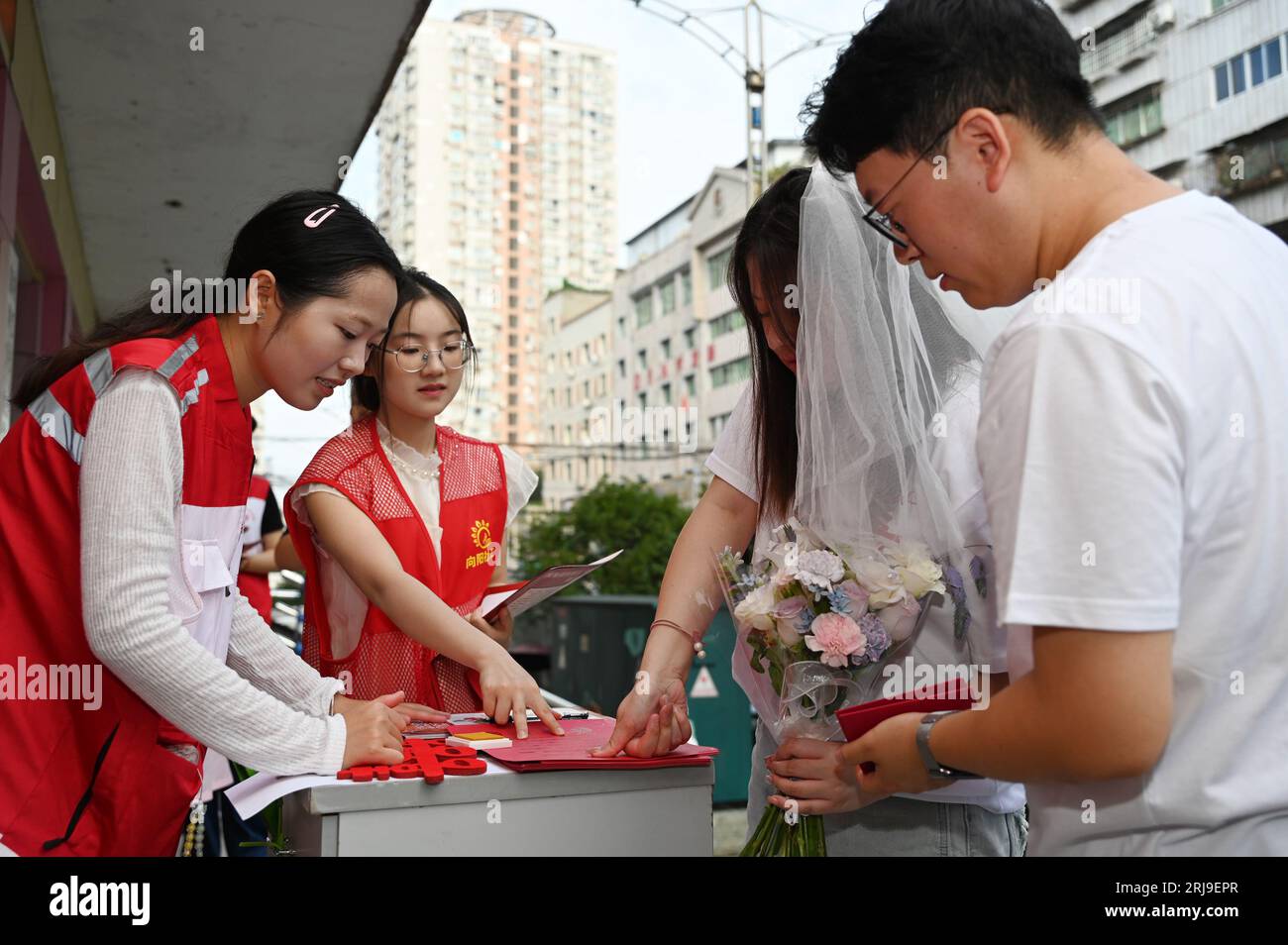 NEIJIANG, CHINA - AUGUST 22, 2023 - A social worker guides a couple to ...