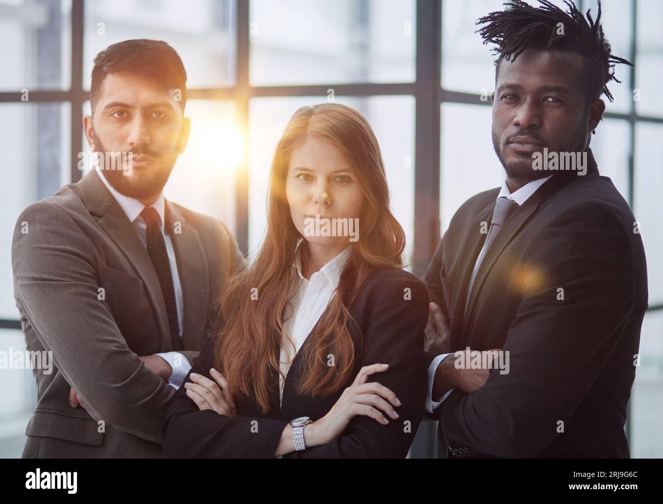 a group of three employees posing together with their arms crossed ...