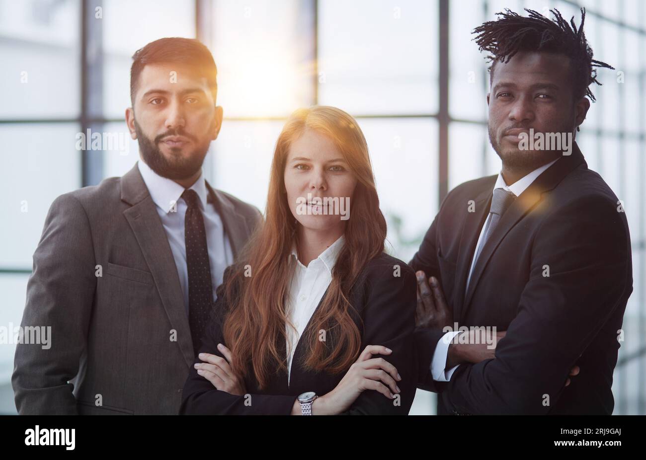 a group of three employees posing together with their arms crossed ...