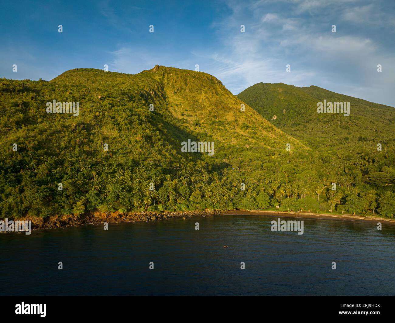 Camiguin Island with mountain cliff, valley, forest and blue sea. Blue ...