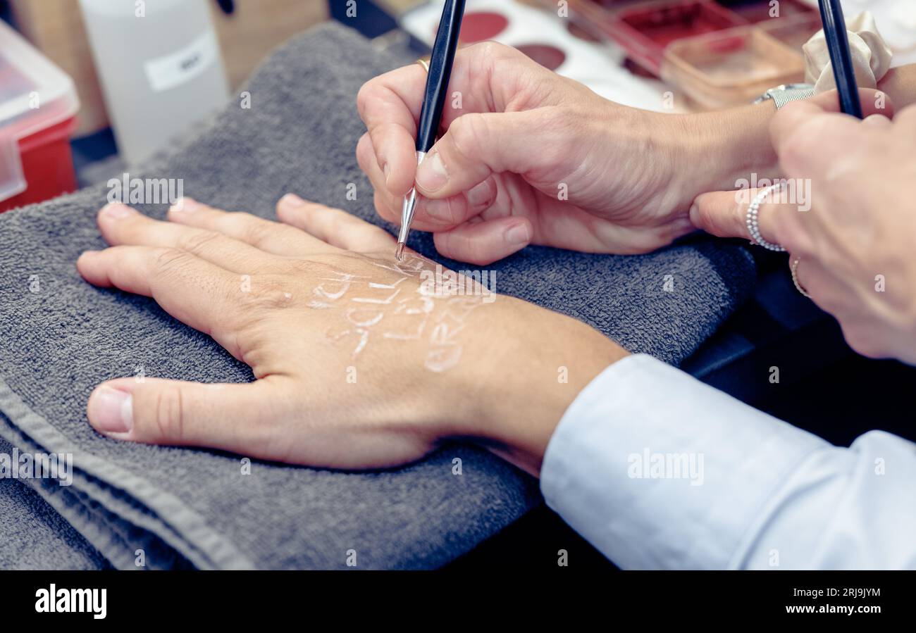 Hamburg, Germany. 17th Aug, 2023. A makeup artist applies a text scar ...