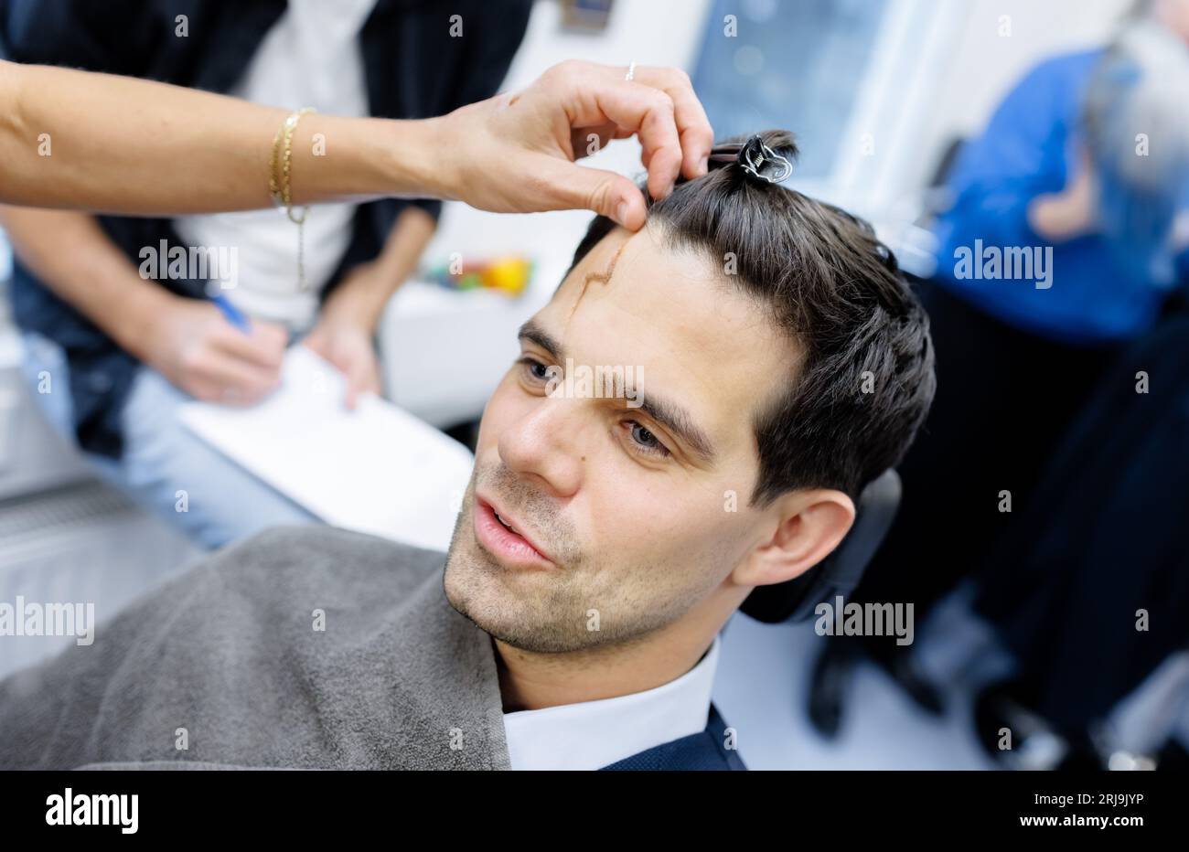 Hamburg, Germany. 17th Aug, 2023. A makeup artist applies a lightning ...