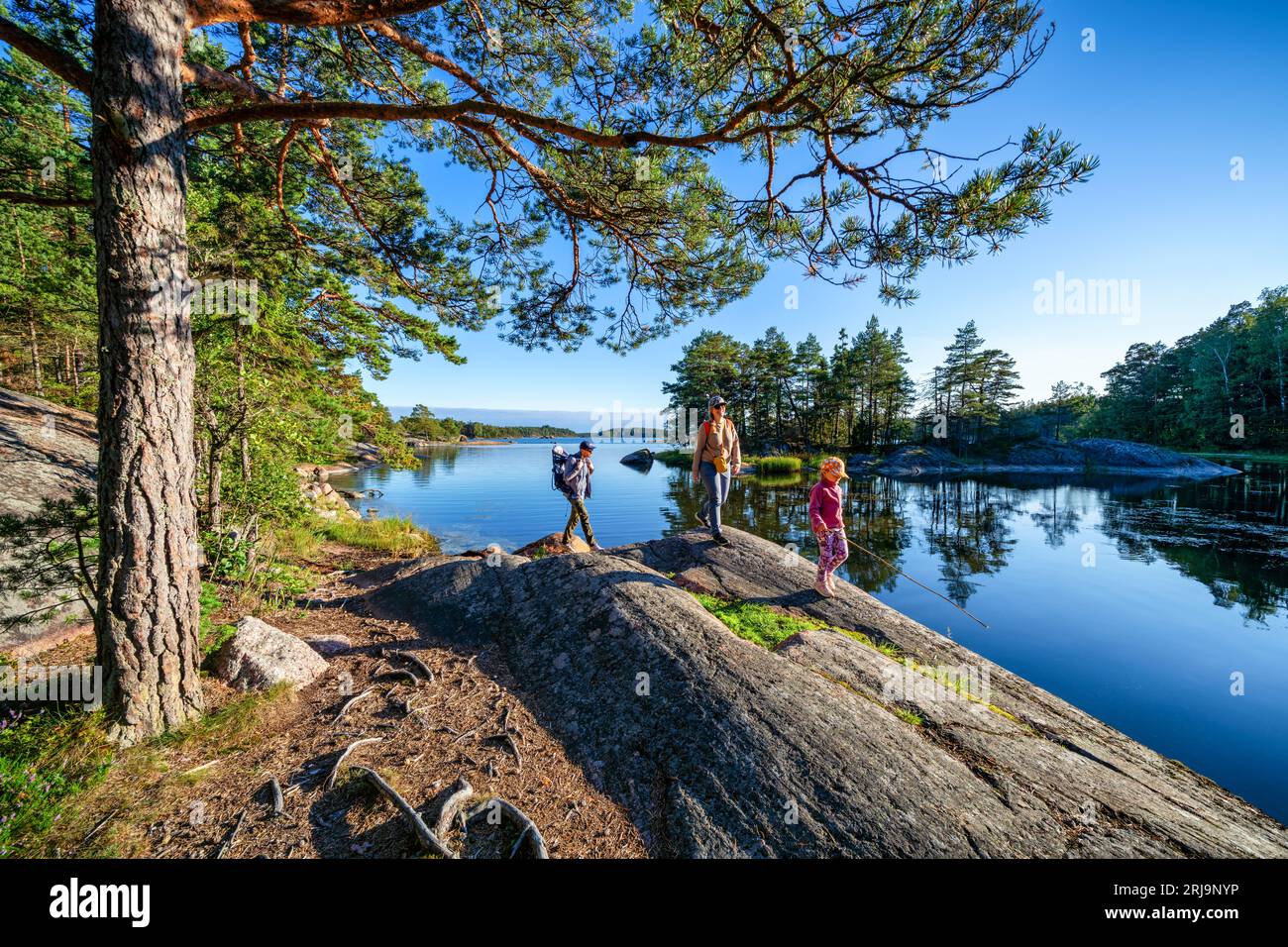 A family hiking by the shore at Linlo island, Kirkkonummi, Finland ...