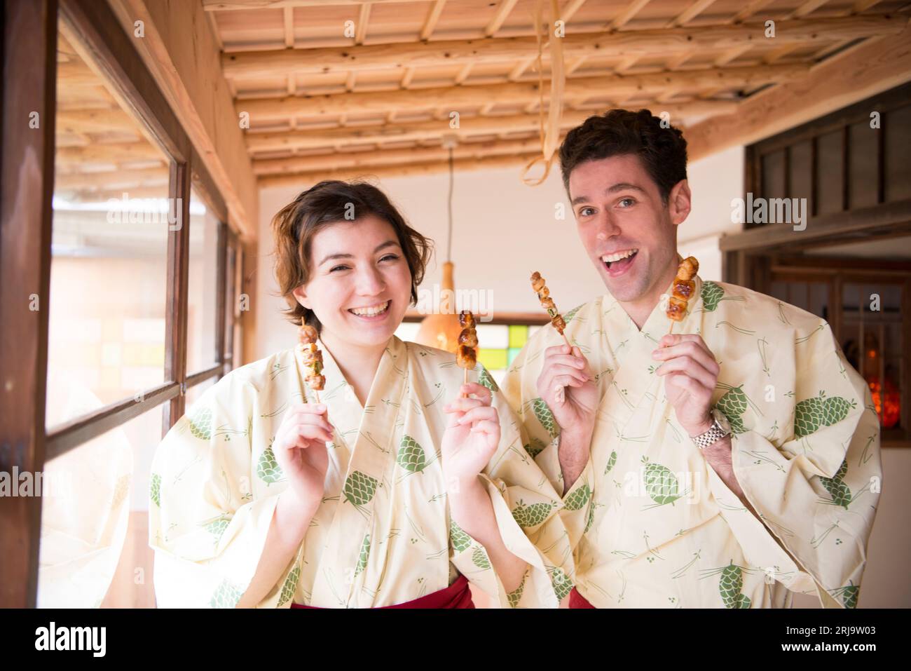 Foreign couple in yukata holding a yakitori Stock Photo - Alamy