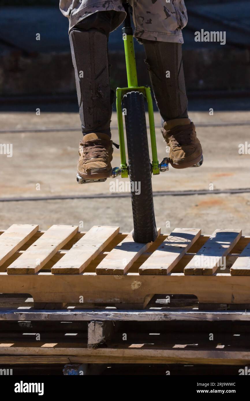a unicycle rider jumping wooden pallets Stock Photo - Alamy
