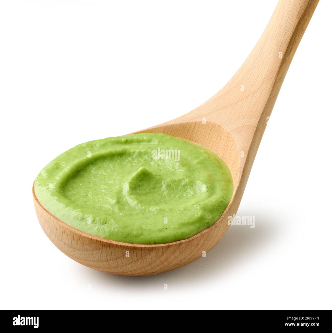 green vegetable puree in wooden ladle isolated on white background ...