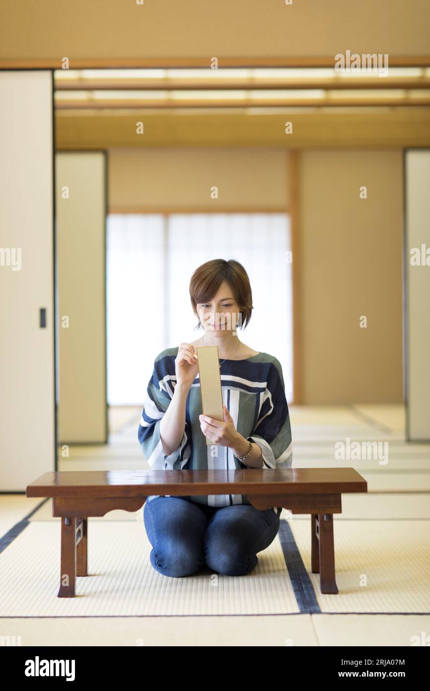 Foreign women writing haiku on strips of paper Stock Photo - Alamy