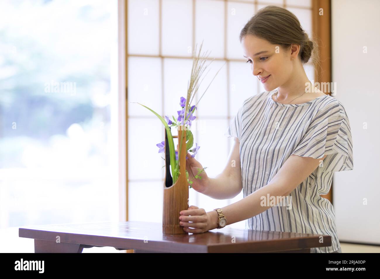 Foreign tourist arranging flowers Stock Photo - Alamy