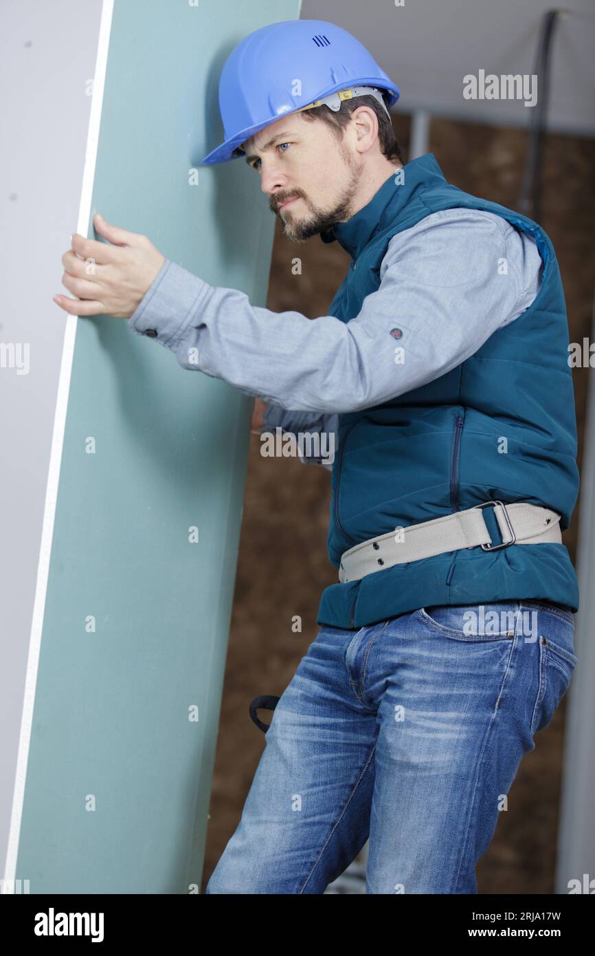 man measuring wall with a tape measure for repair Stock Photo - Alamy