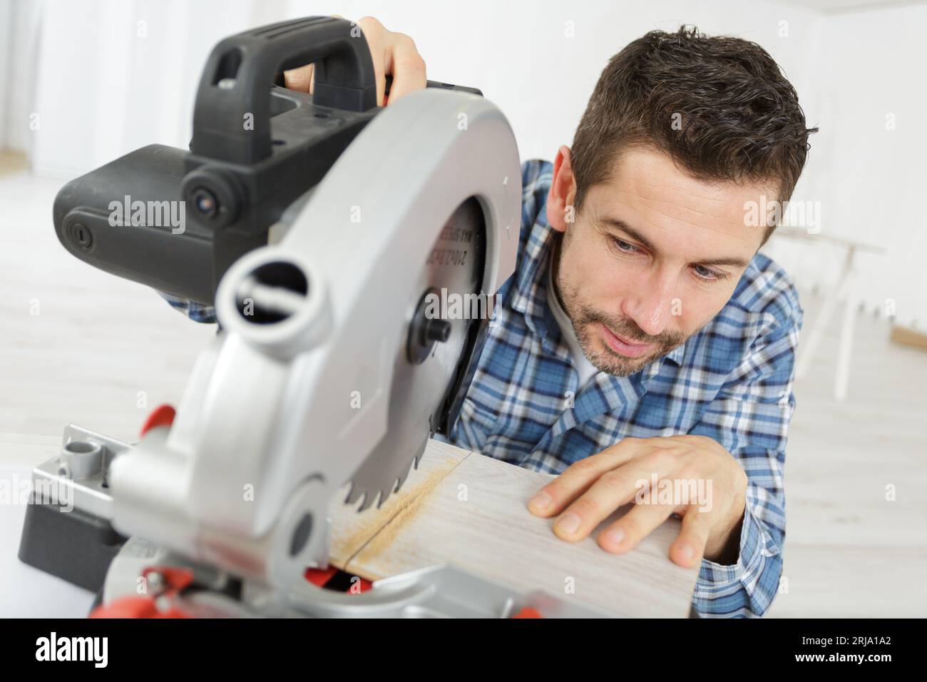 carpenter cutting wooden plank with a circular saw Stock Photo - Alamy