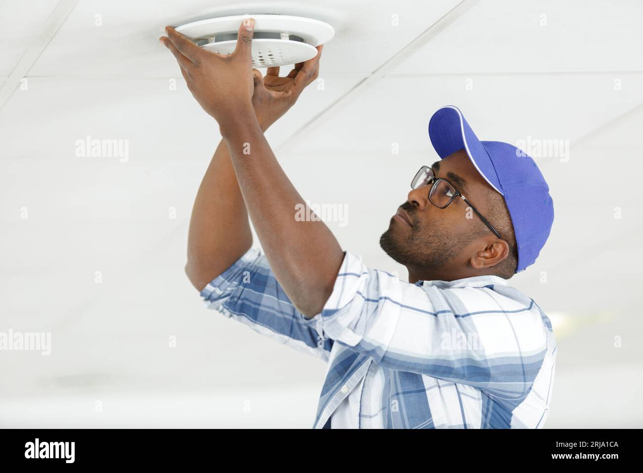 handyman installing a plastic ceiling vent Stock Photo - Alamy