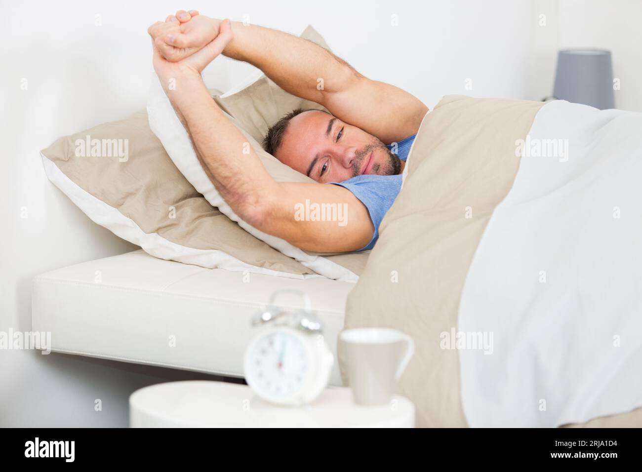 single man stretching in bed Stock Photo - Alamy
