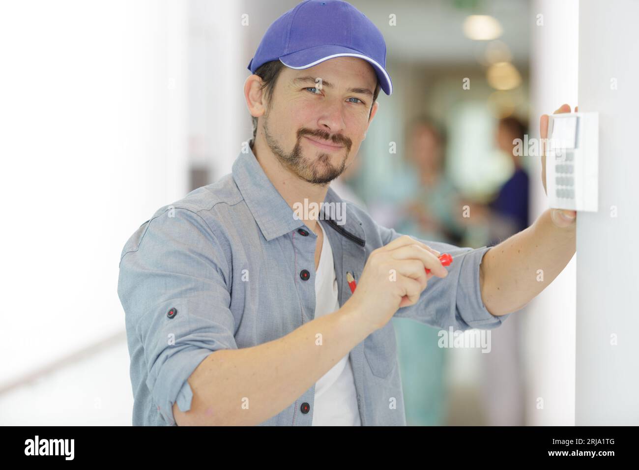 male electrician installing security system door sensor on wall Stock ...