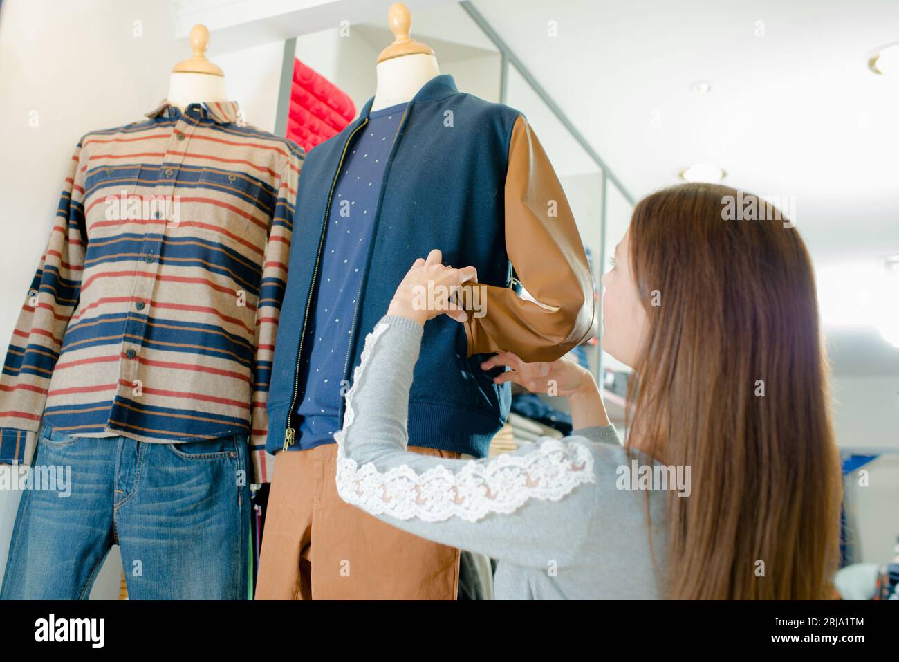 Lady adjusting clothes on male mannequin Stock Photo - Alamy